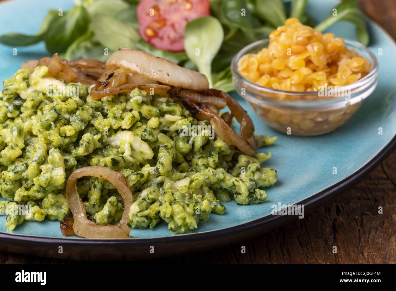 Bavarian spinach spaetzle on a blue plate Stock Photo - Alamy