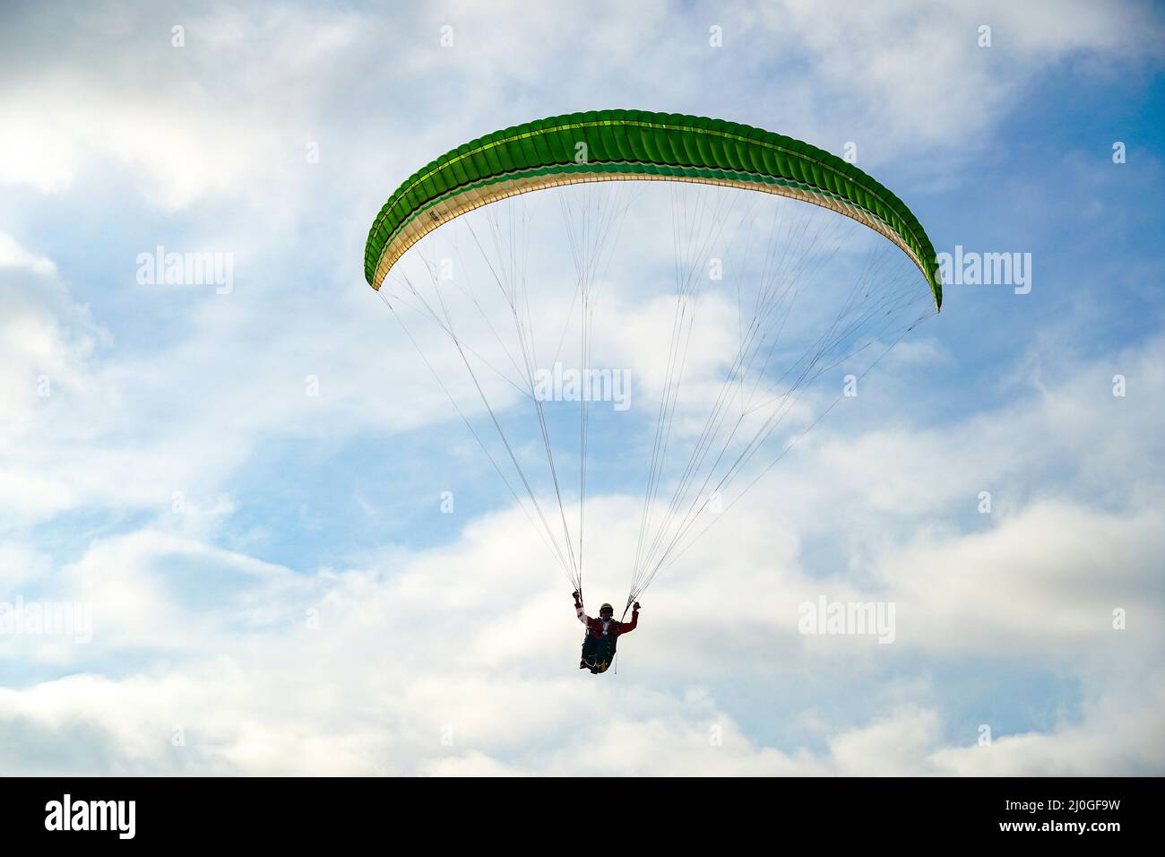 Man doing sport, Para-glider in the clouded sky Stock Photo - Alamy