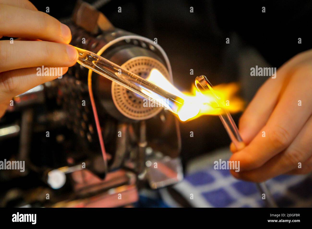 Glass sticks are heated in order to process them artistically Stock ...
