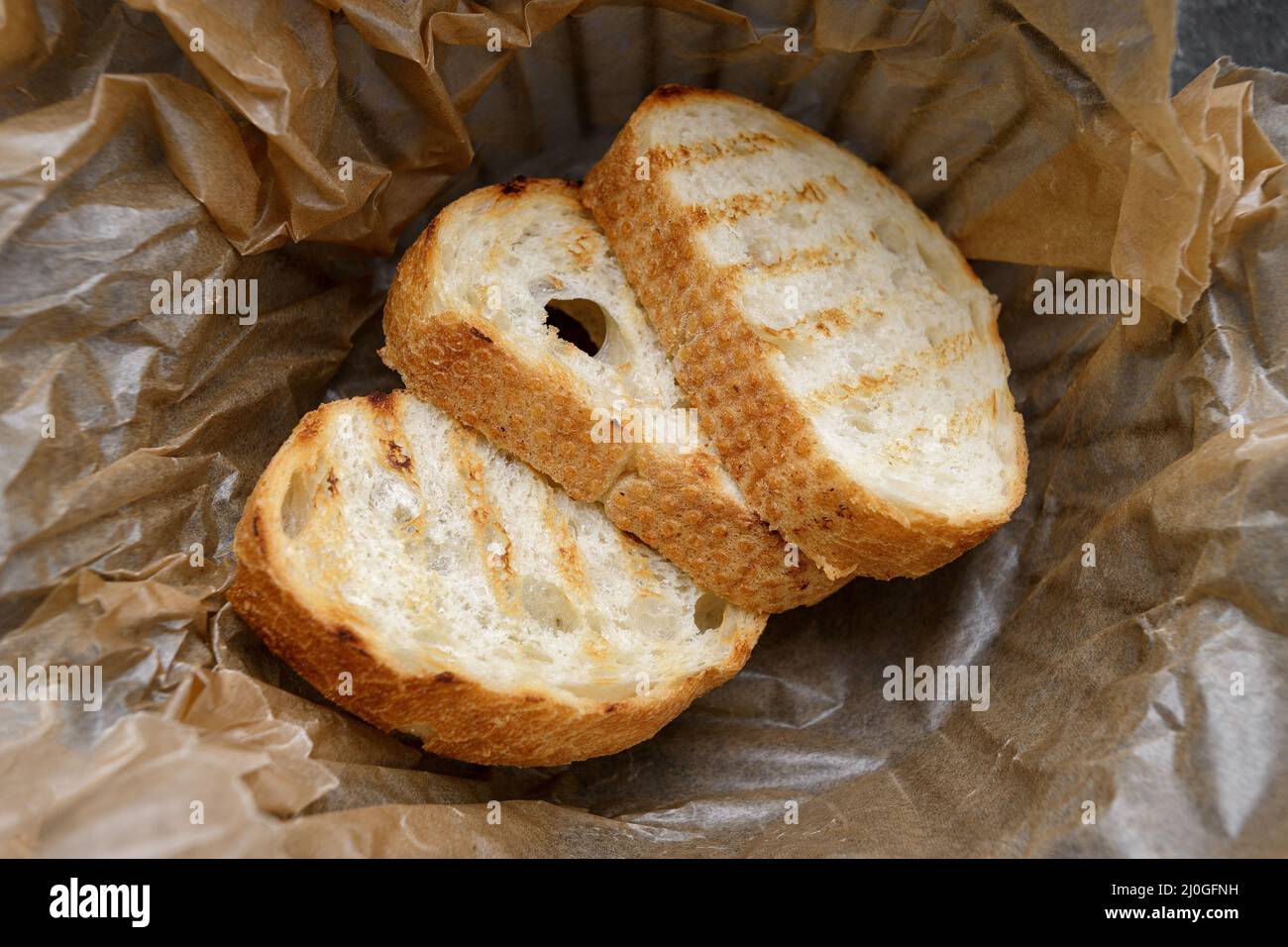 grilled white bread toasts on craft paper Stock Photo - Alamy