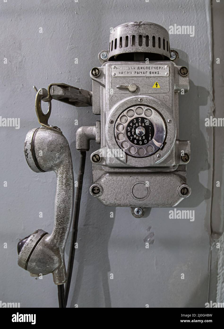 Old metal wall-mounted telephone with rotary dial. Antique phone with ...