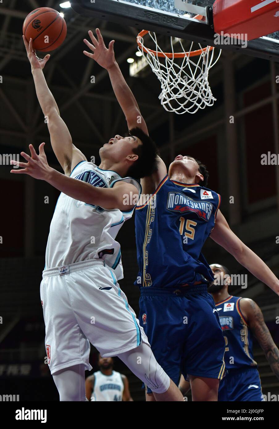 Shenyang. 19th Mar, 2022. Lyu Junhu (L) of Qingdao Eagles goes for a ...