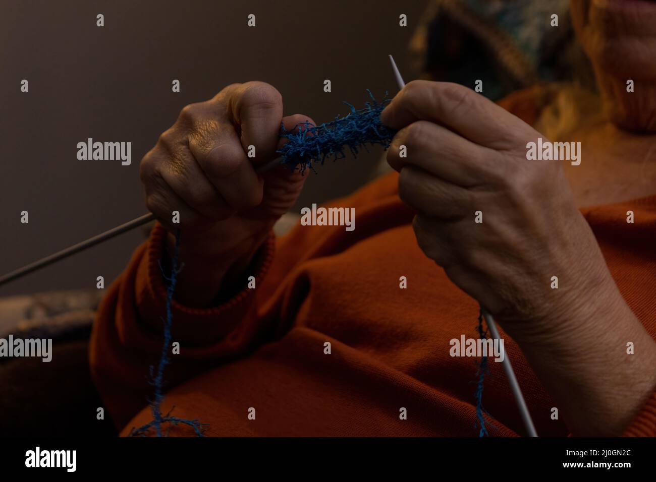Hands of an older woman knitting a small patch of blue fabric Stock ...
