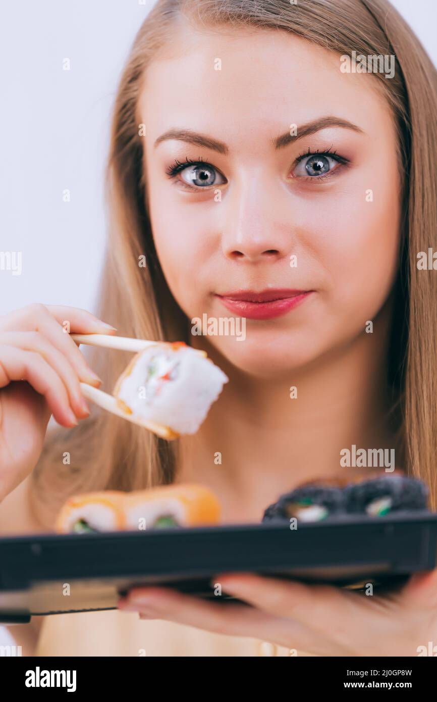 Beautiful girl trying Japanese food rolls, close-up Stock Photo - Alamy