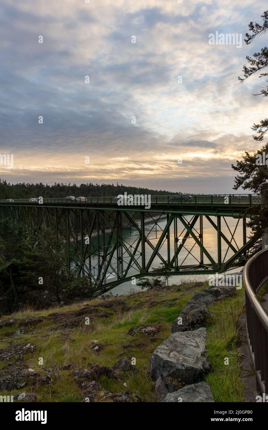 an old green bridge crossing from one cliff to another high above the ...