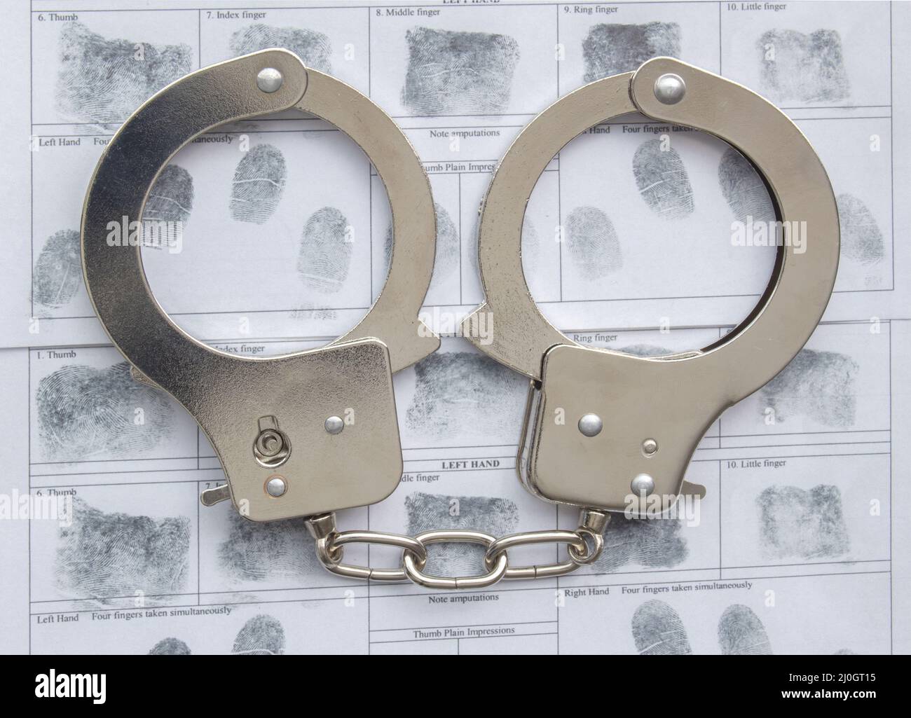 Top view of metal Handcuffs with generic hand prints Stock Photo - Alamy