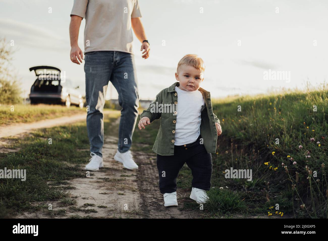 Funny Toddler Boy Trying to Walk Without Help from His Father Outdoors ...