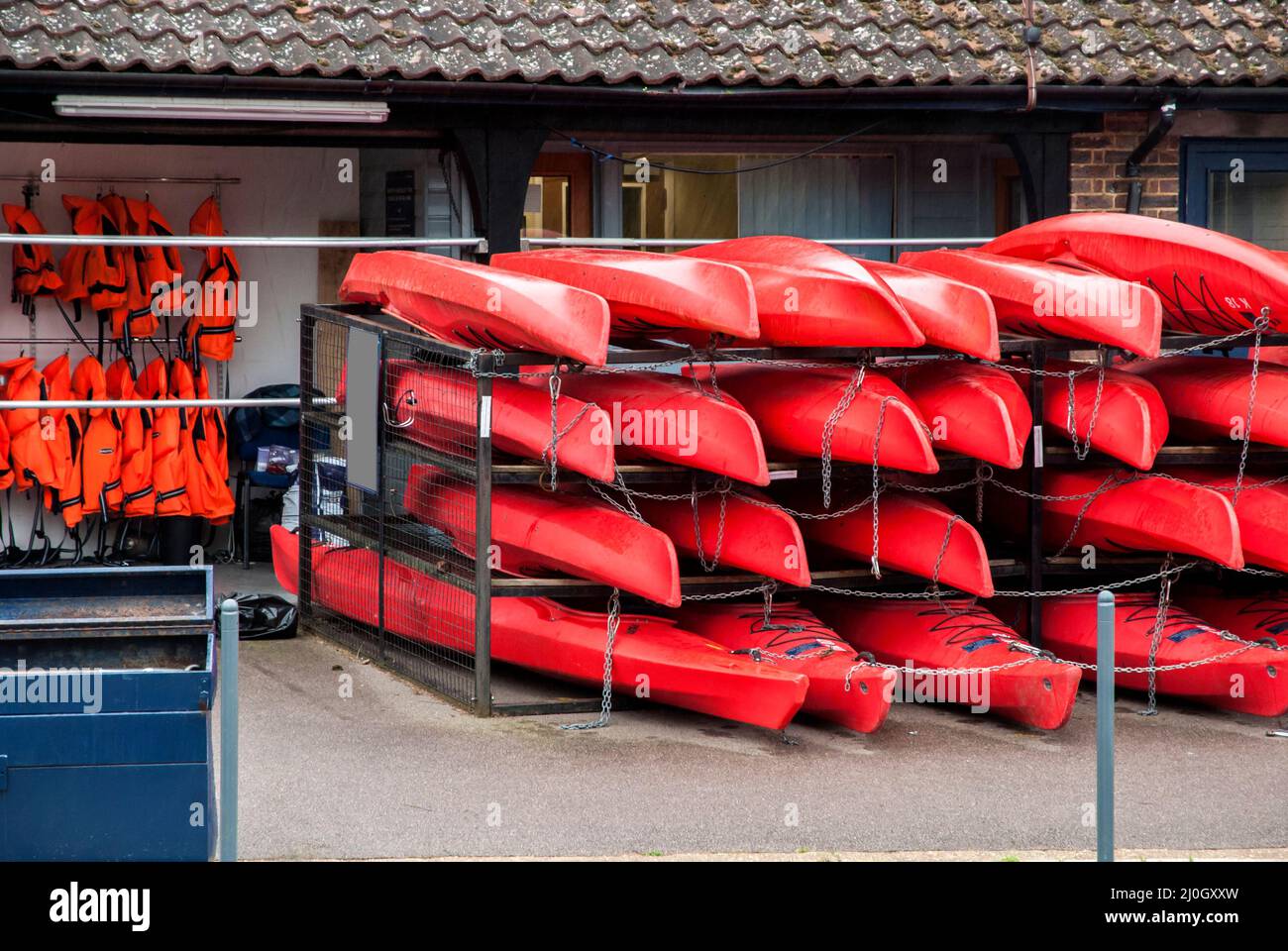 Storage of red kayaks and boats in hangar Stock Photo - Alamy