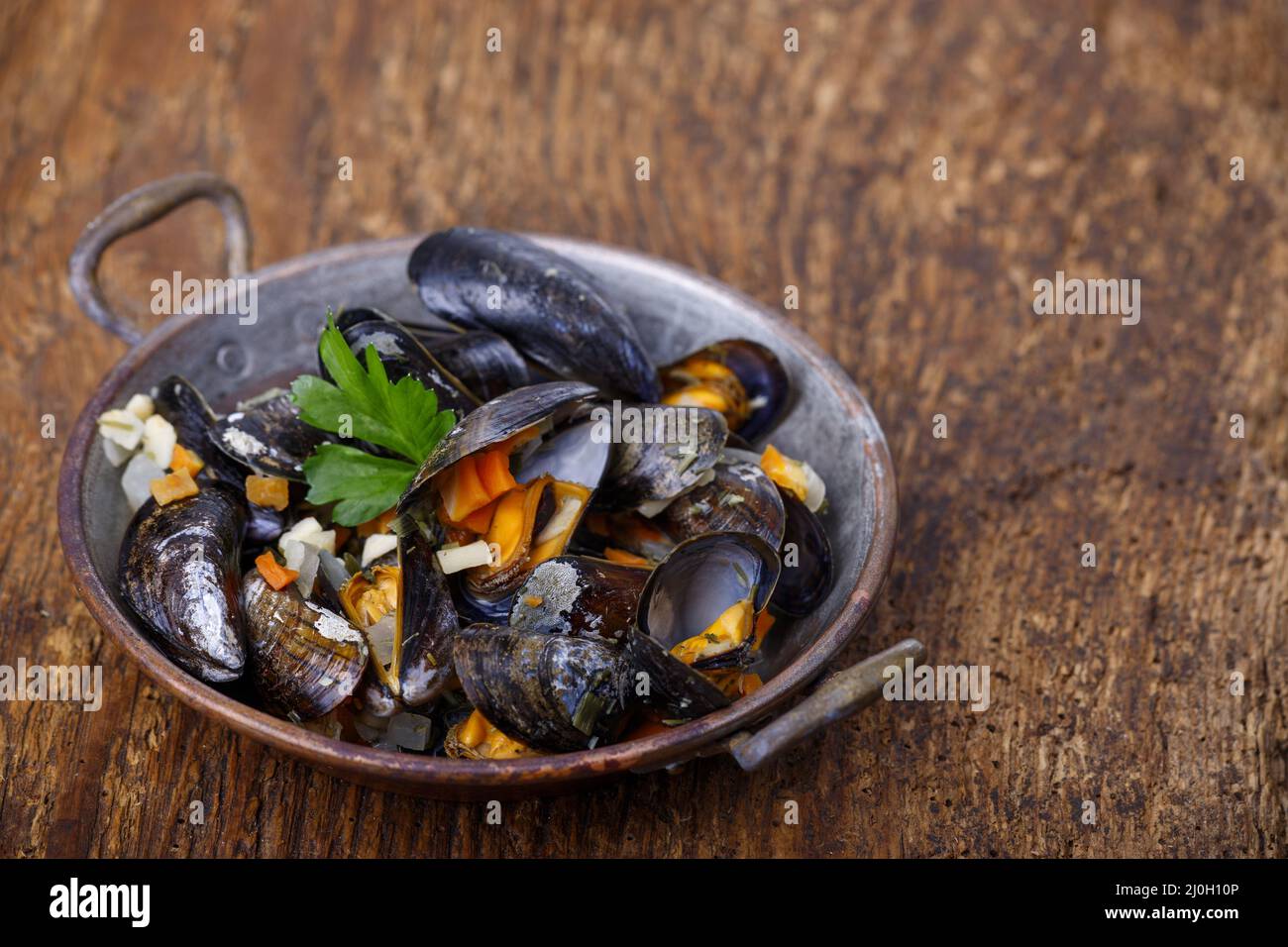 Cooked mussels on dark wood Stock Photo - Alamy