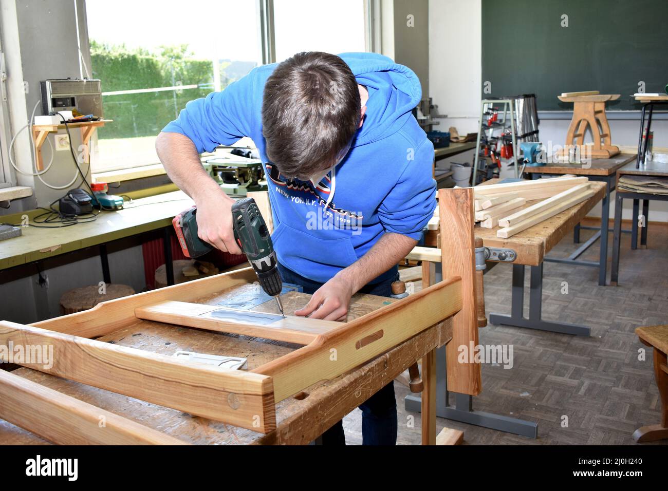 Carpenter screws with cordless screwdriver - craftsman Stock Photo - Alamy