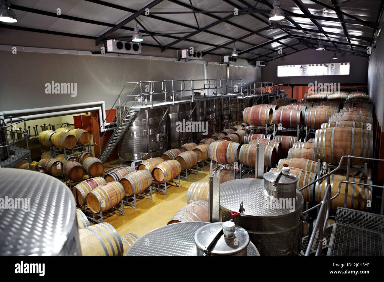 The winemaking process. Wine barrels and fermentation vessels in a ...