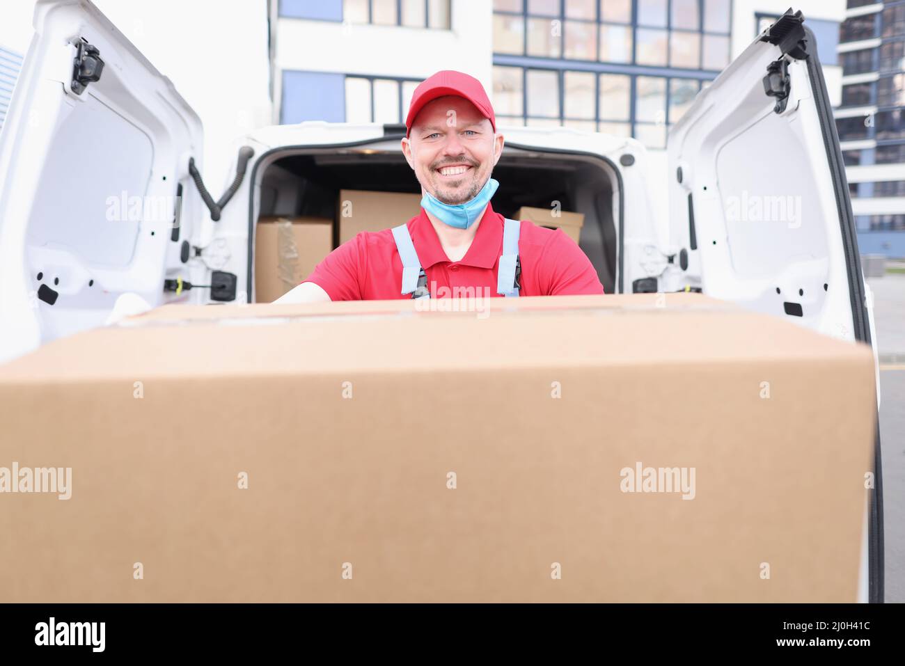 Happy postman worker carry cardboard package, delivery on address Stock ...