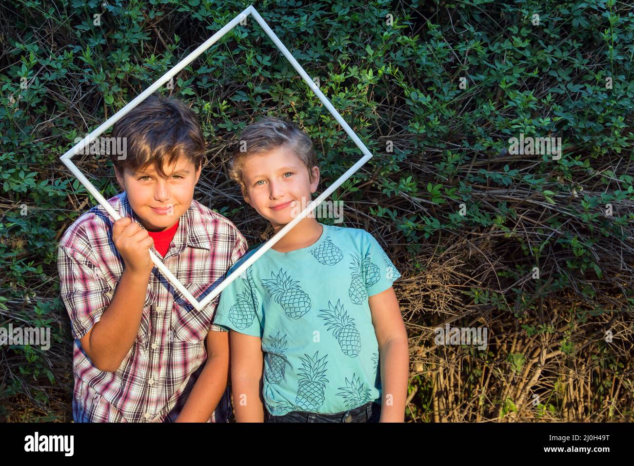 Two brothers looking through frame Stock Photo - Alamy