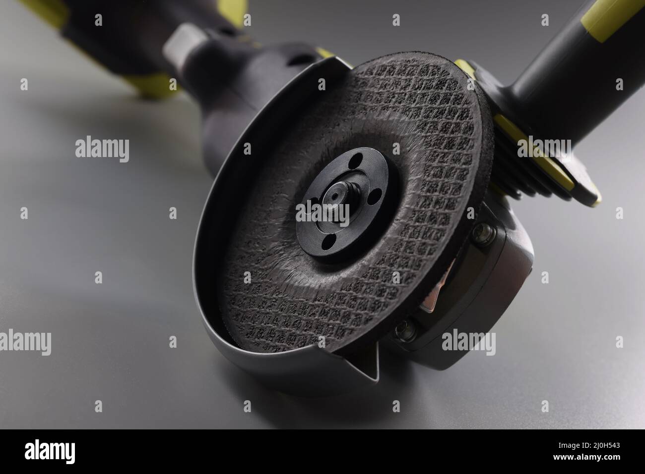 Grinder instrument for metal works, electrical saw on grey background ...