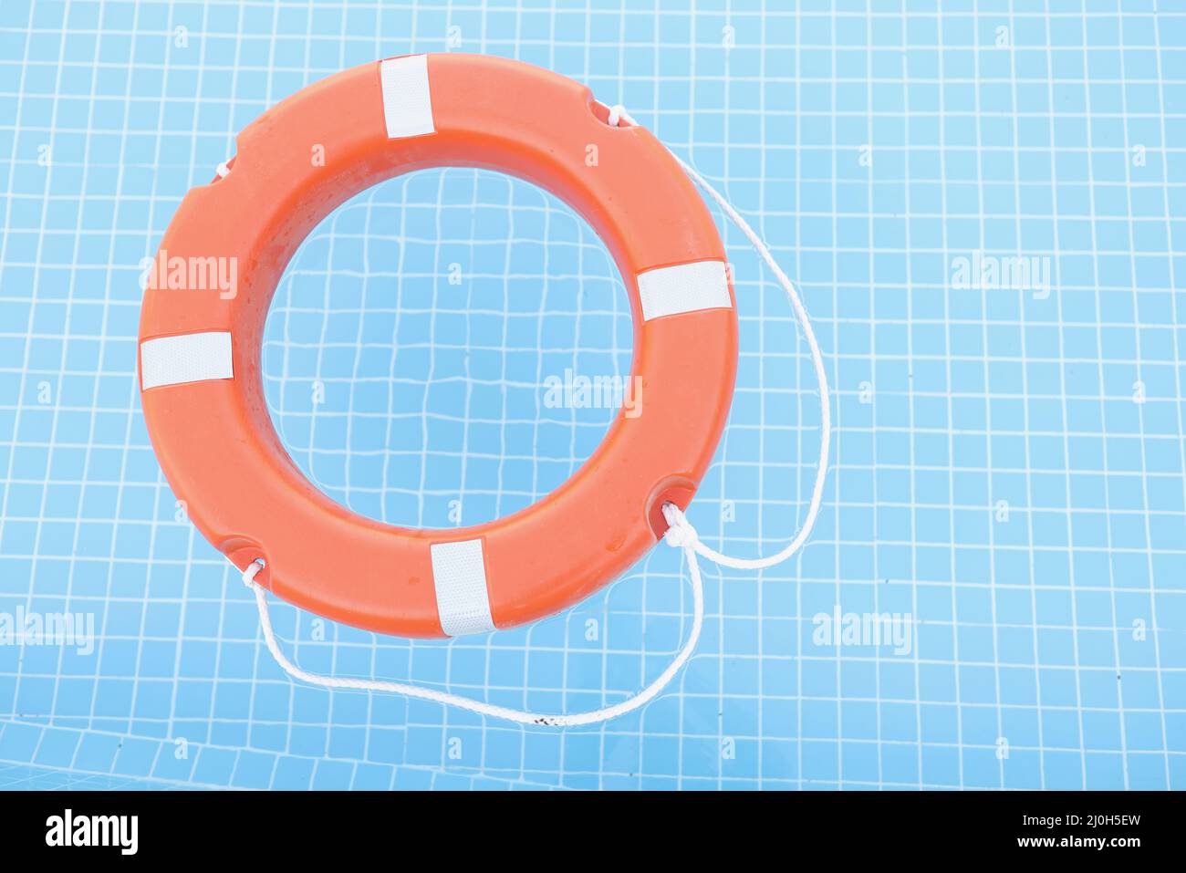 Red safety equipment floating on swimming pool to rescue people from ...