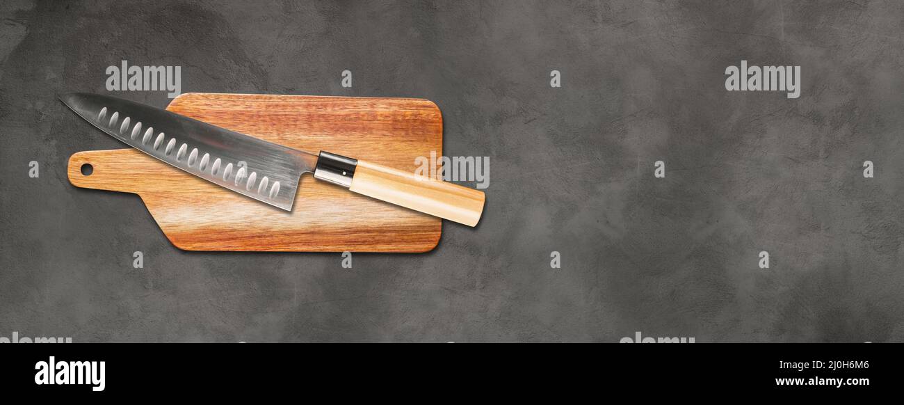 Traditional Japanese gyuto chief knife on a cutting board. Concrete ...