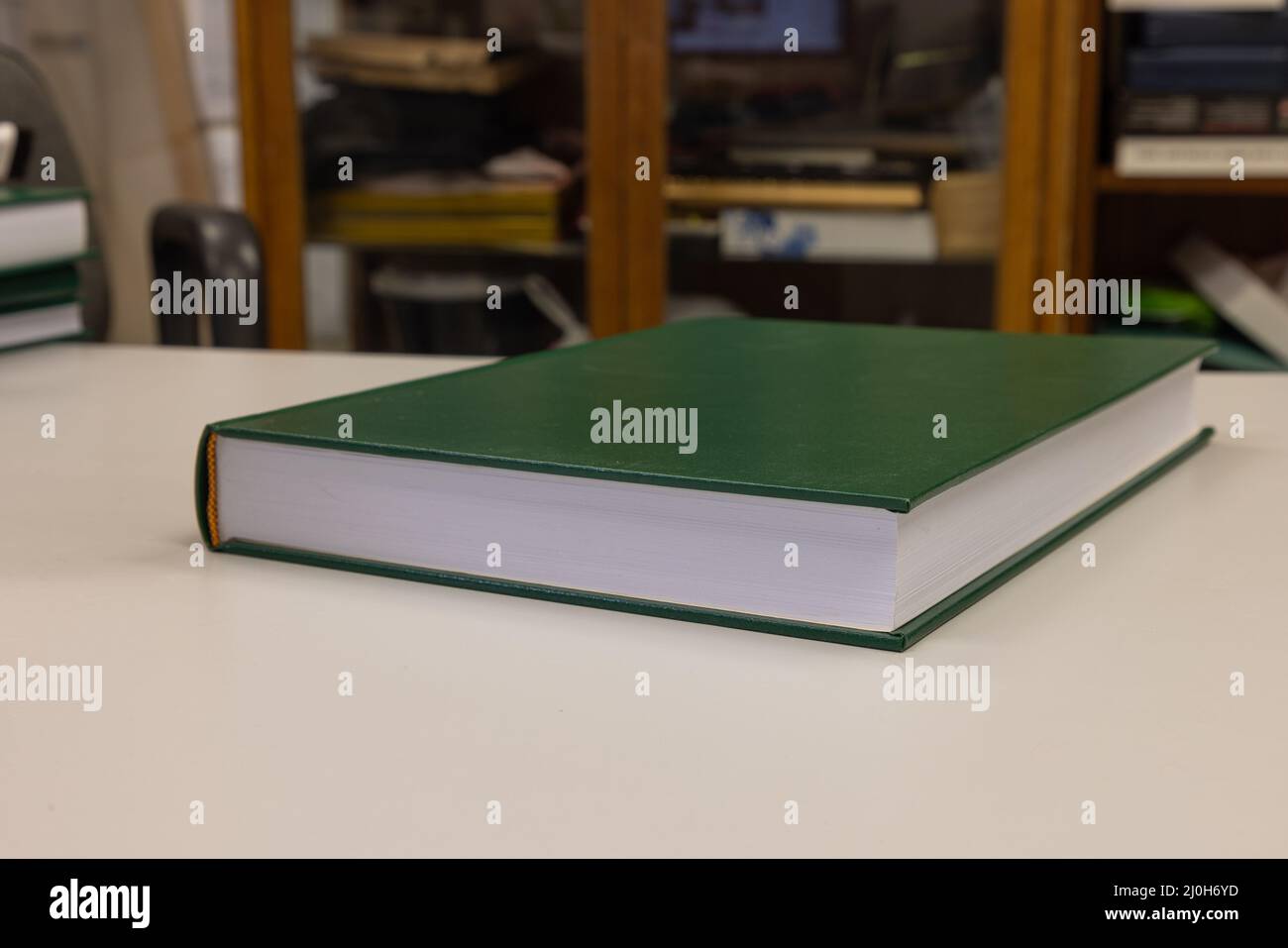 a PhD thesis of green cover, office background Stock Photo - Alamy