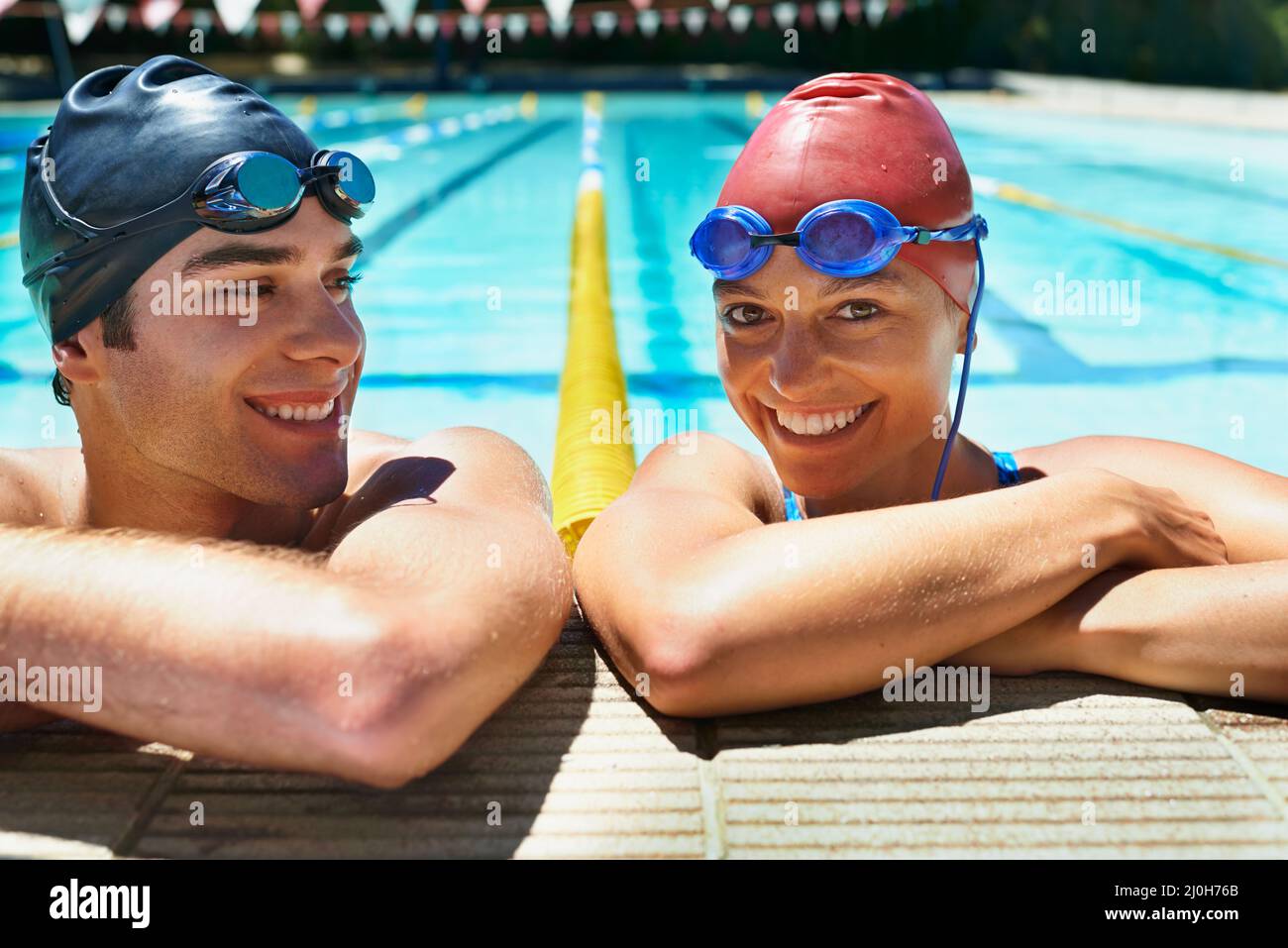 Ready for another lap. Two happy young swimmers standing in the pool ...