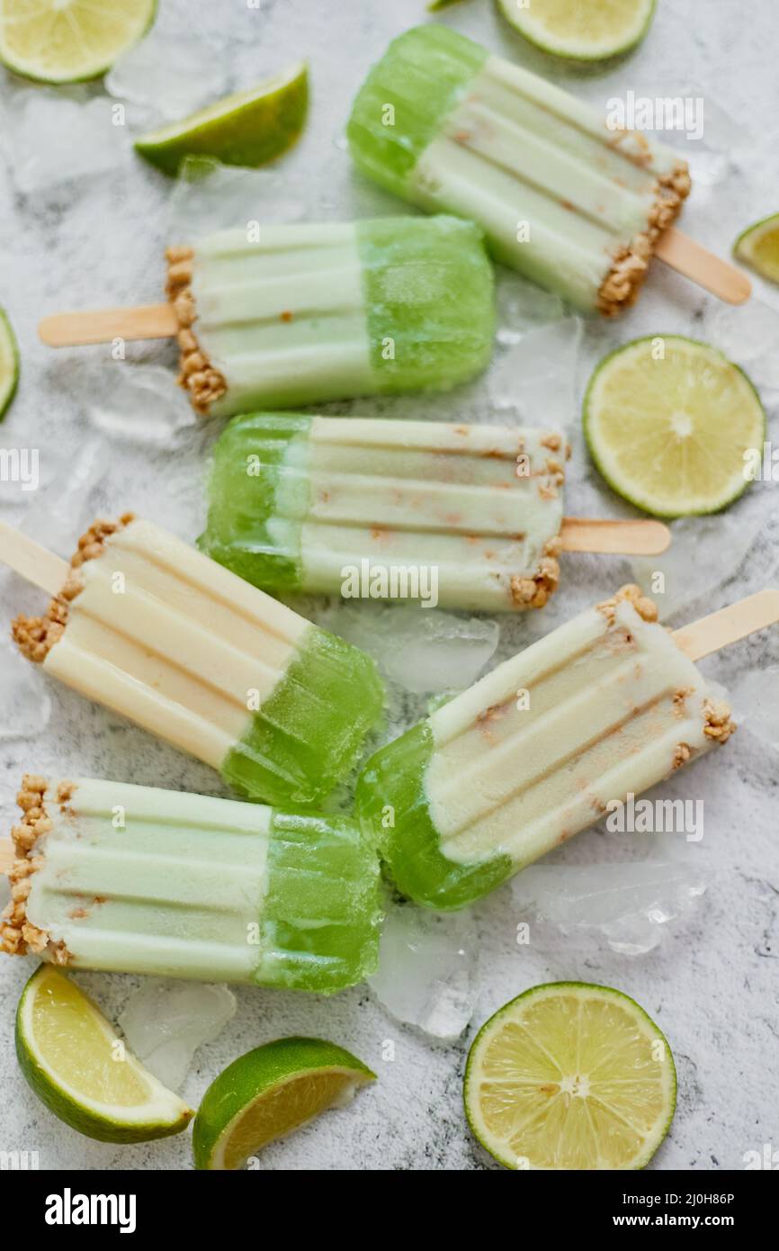 Lime and cream homemade popsicles or ice creams placed with ice cubes ...