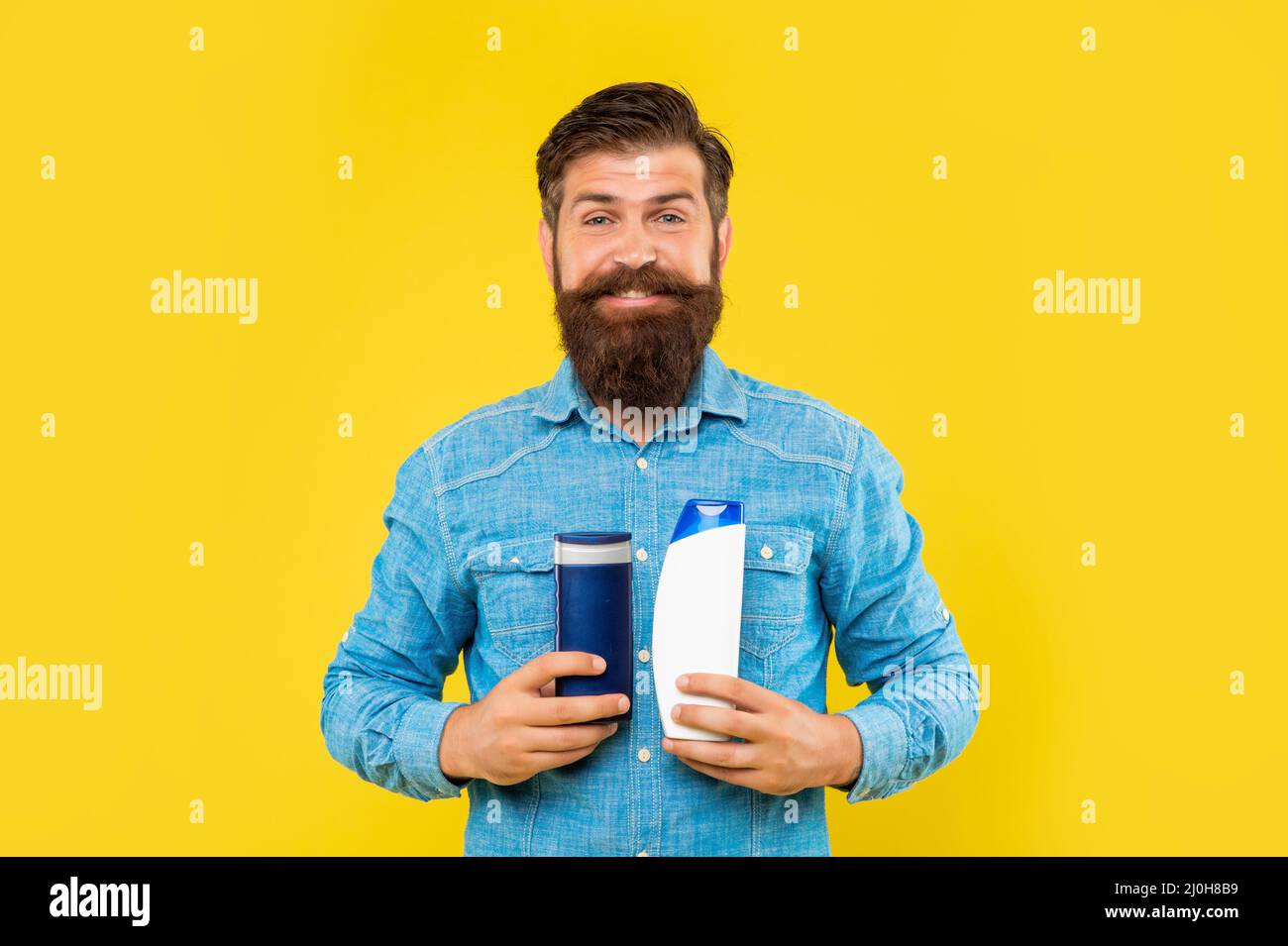 glad brutal bearded man hold hair conditioner bottle on yellow ...