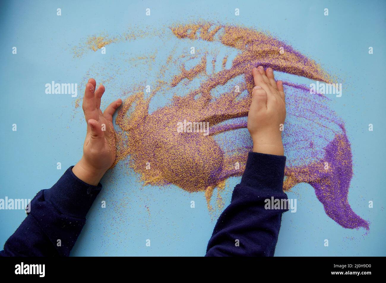 Toddler plays with colorful sand. Child fine motor skills development ...
