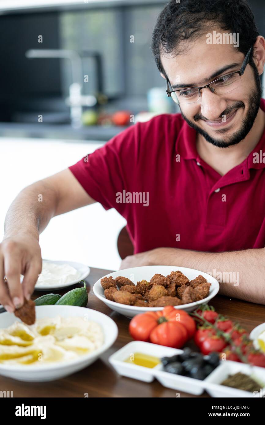 Middle Eastern young man sitting and eating traditional food Stock ...