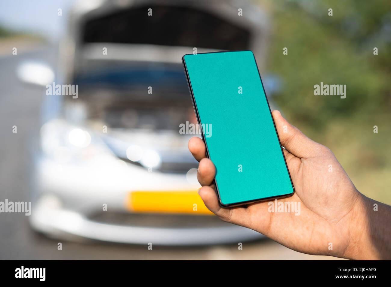 Close up shot of hands showing green screen mobile phone in front of ...