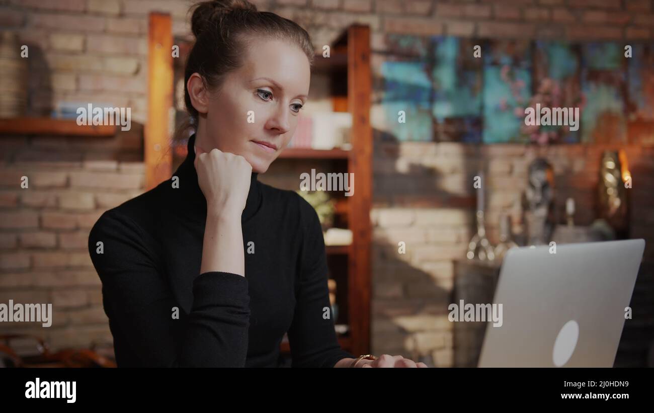 Adult woman in 30s working on laptop in home office, working from home ...