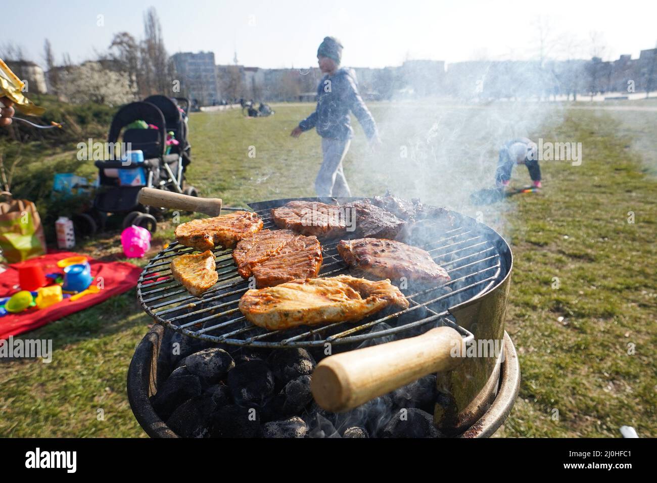 19 March 2022, Berlin: A barbecue will be held in Mauerpark in sunny ...