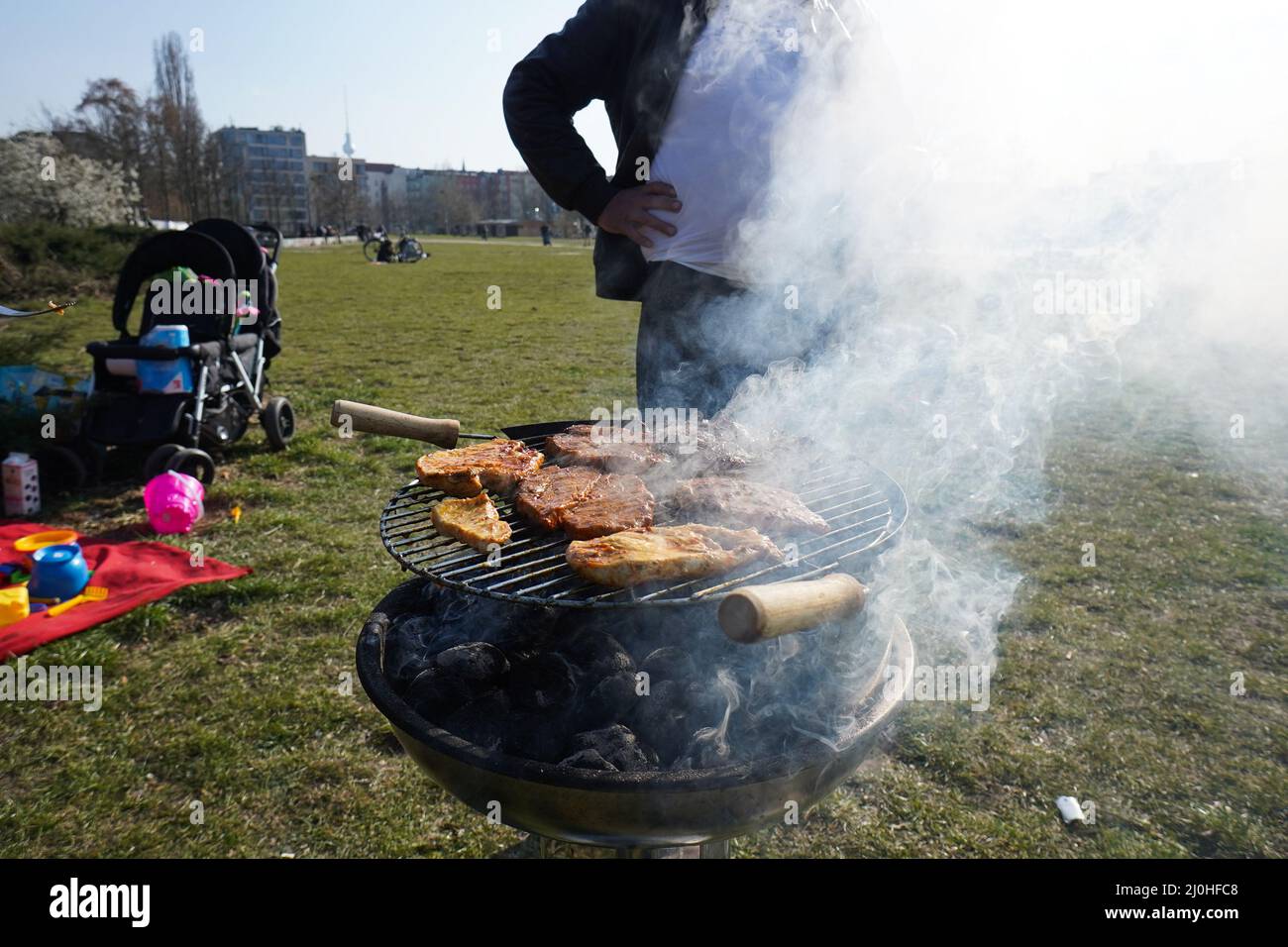 19 March 2022, Berlin: A barbecue will be held in Mauerpark in sunny ...