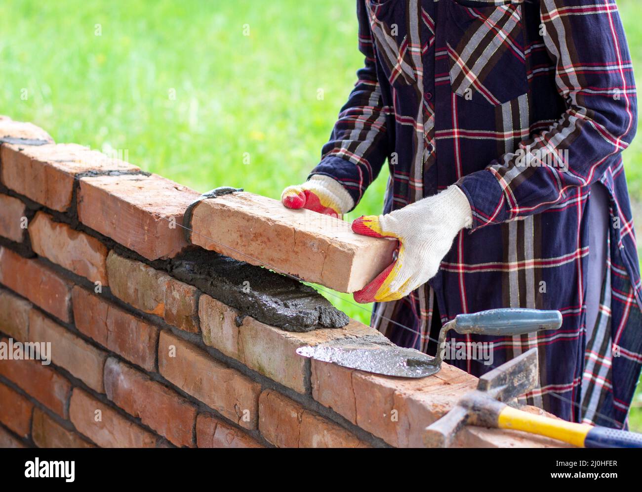 Young woman builds a wall of bricks Stock Photo - Alamy