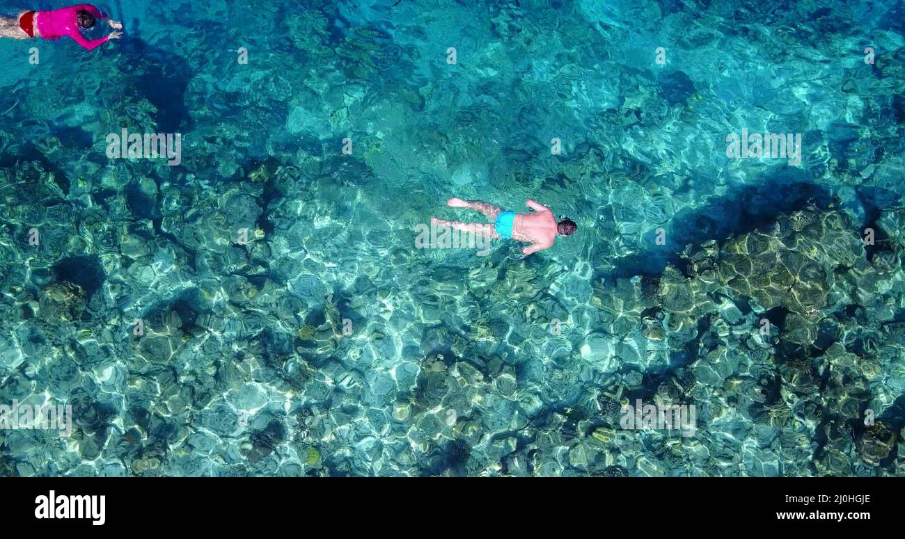 Bird's eye view of a couple swimming in the azure water Stock Photo - Alamy