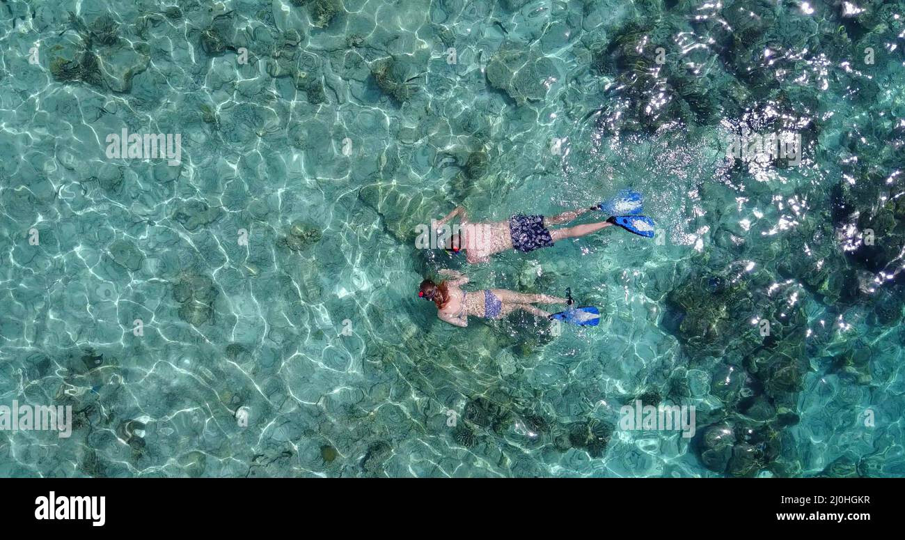 Bird's eye view of a couple diving the azure water Stock Photo - Alamy