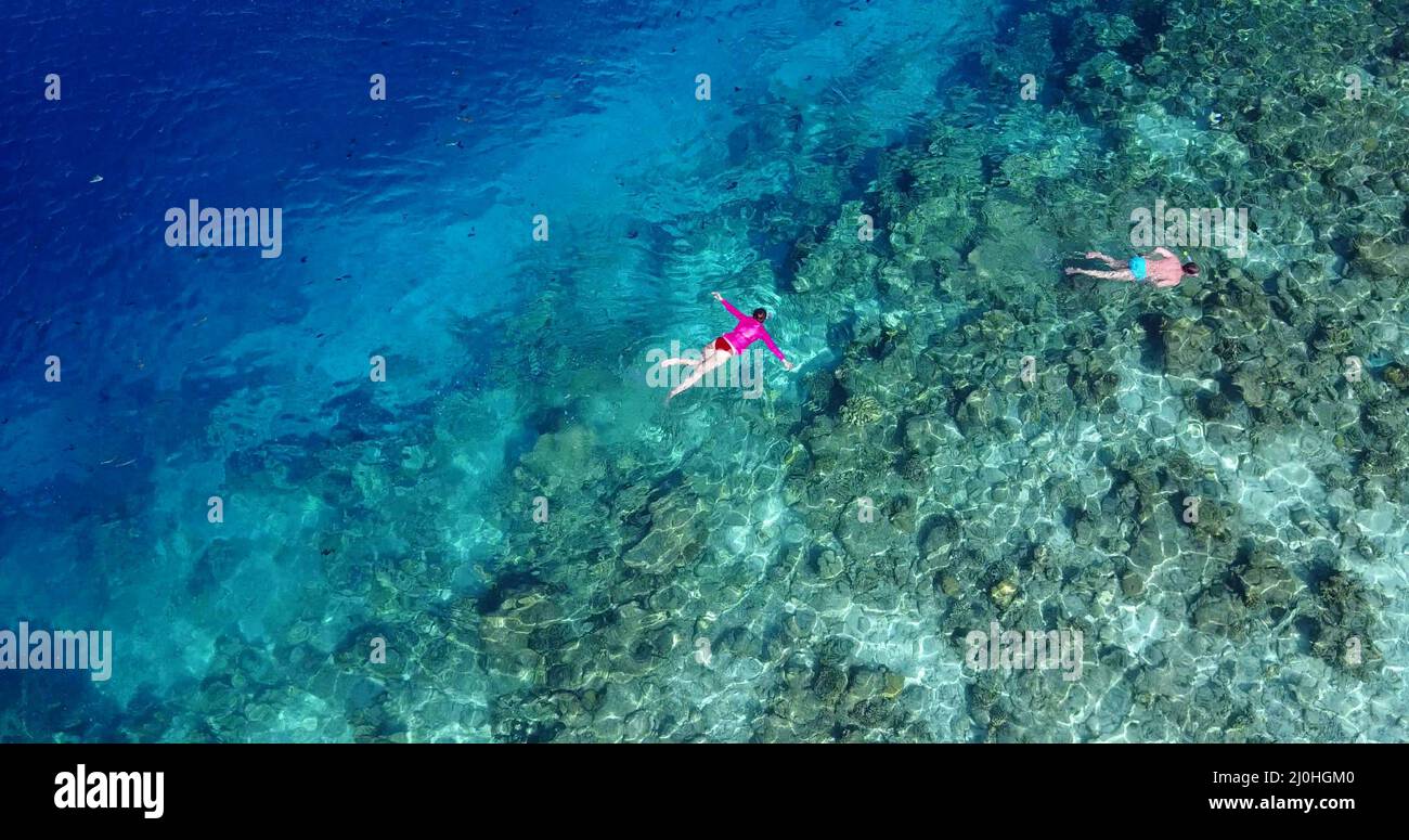 Bird's eye view of a couple diving the azure water Stock Photo - Alamy