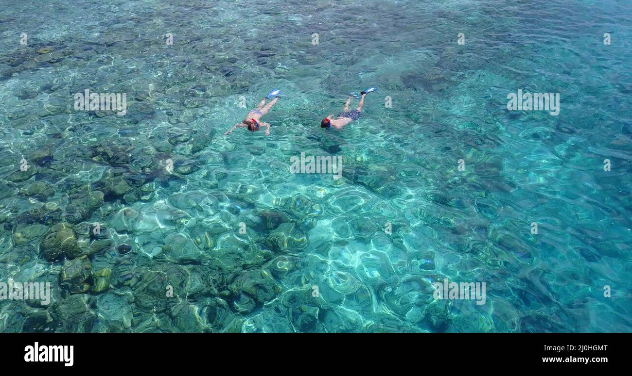 Bird's eye view of a couple diving the azure water Stock Photo - Alamy