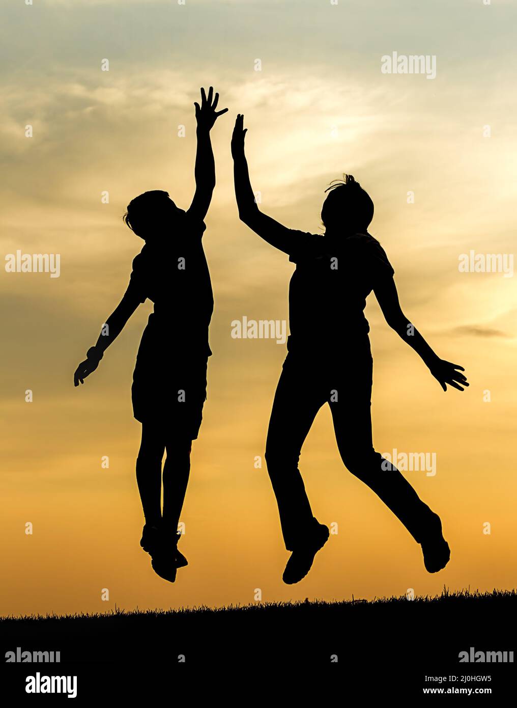 Kids giving a high five at sunset Stock Photo - Alamy