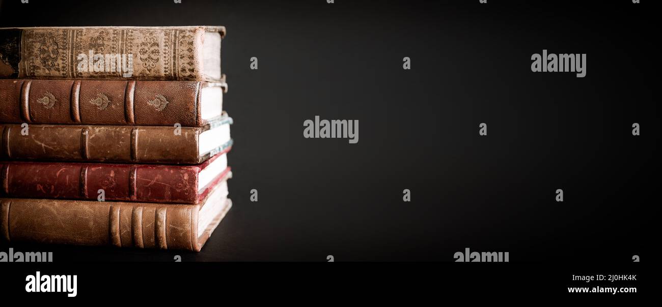 Stack of old books on black background banner Stock Photo - Alamy