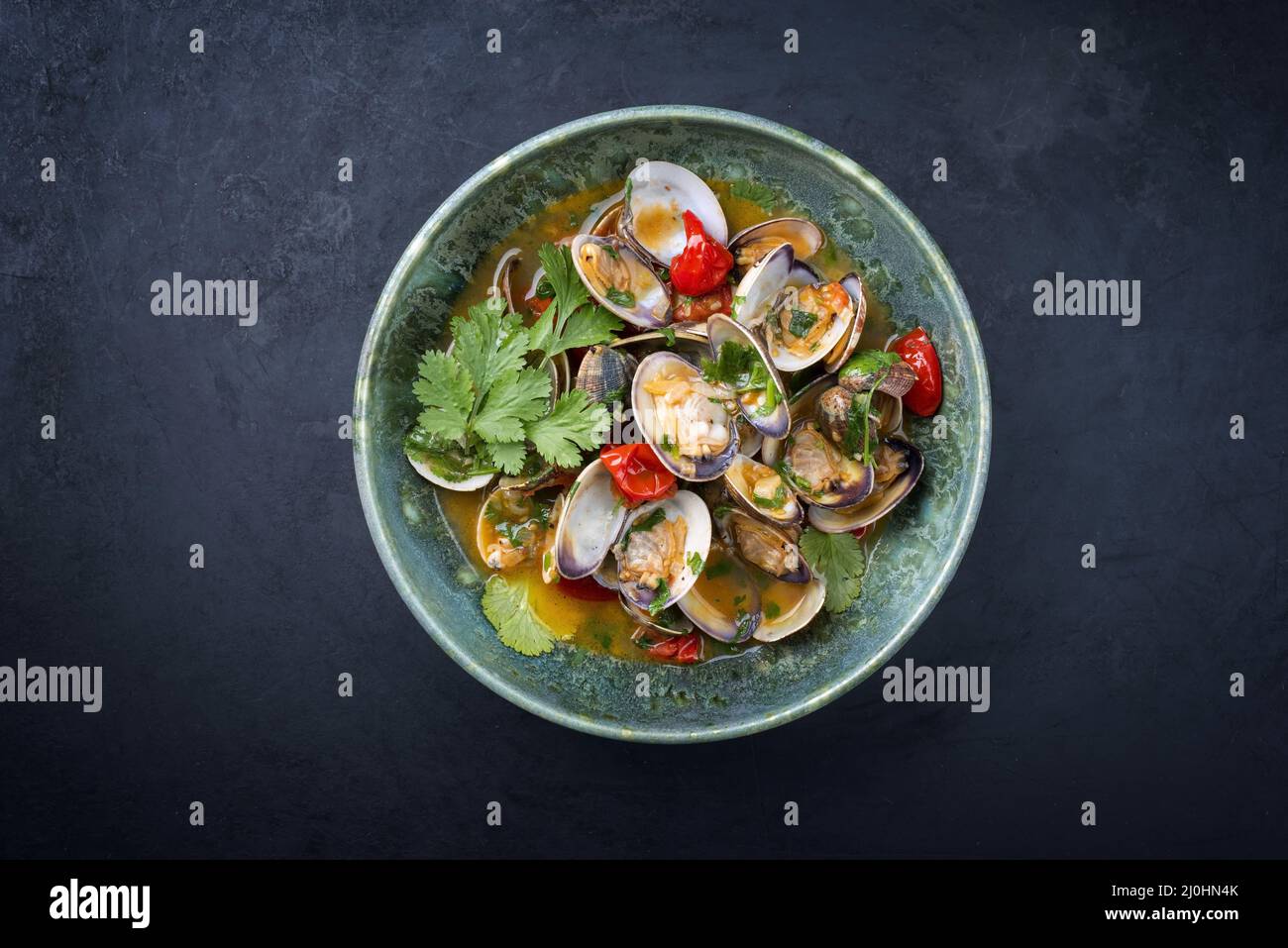 Modern style traditional Italian venus clams soup with tomatoes and ...