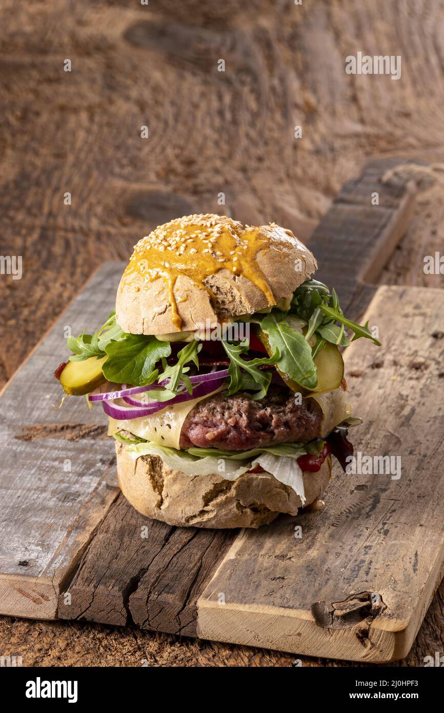 Homemade cheeseburger on dark wood Stock Photo - Alamy
