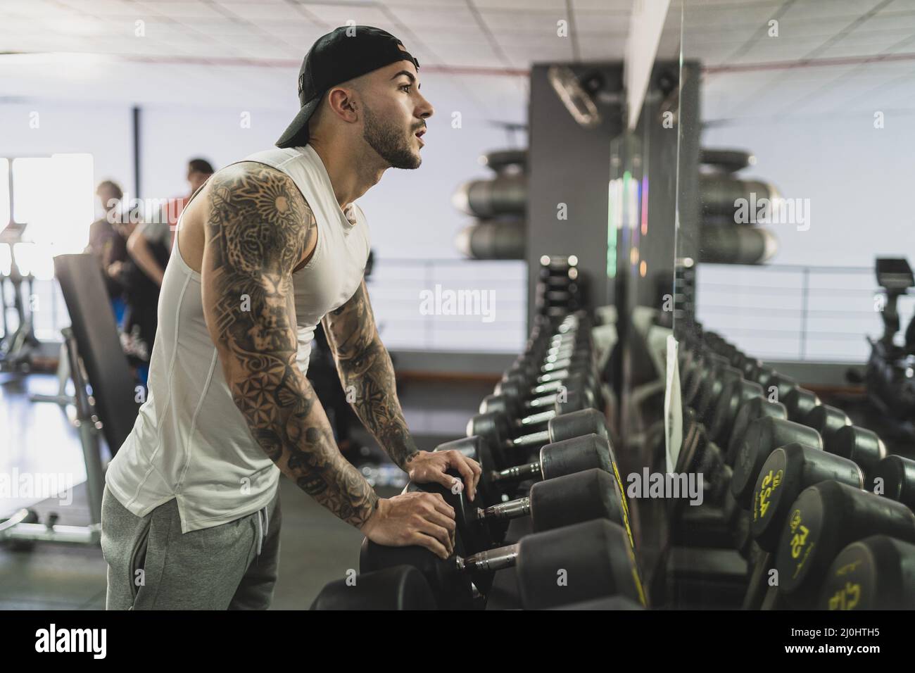 Handsome man doing a workout in the gym Stock Photo - Alamy