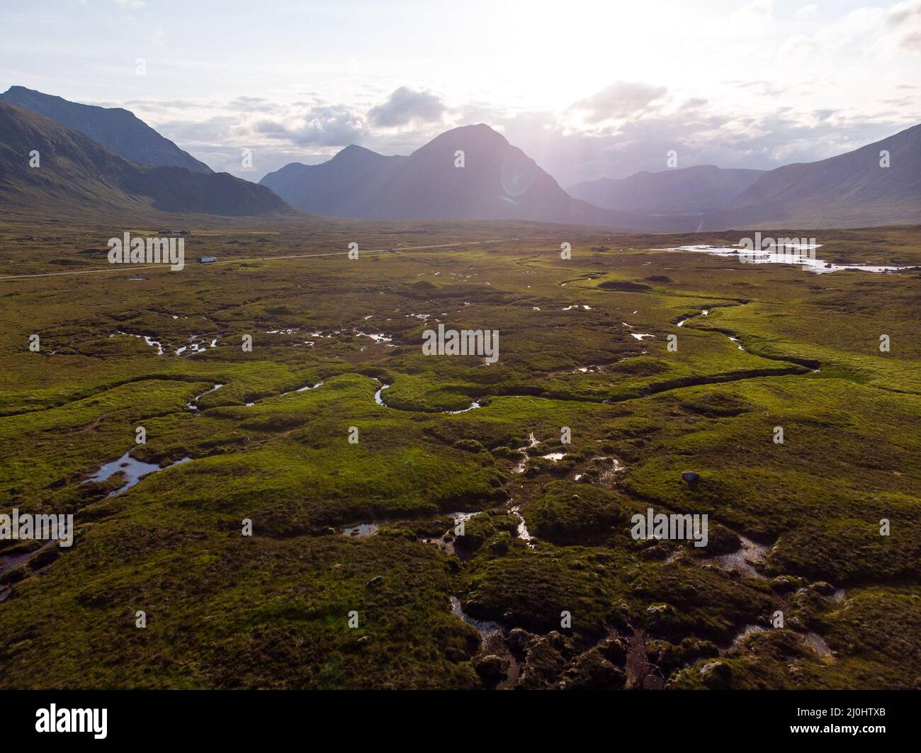 Aerial view of green valleys with flowing streams near mountains on a ...