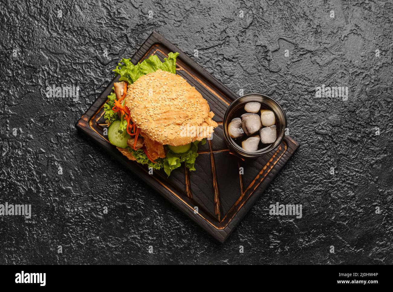 Fresh doner kebab in bun with glass of cola drink on dark background ...