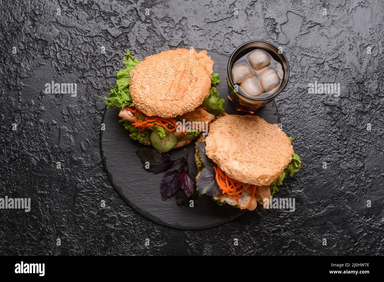 Fresh doner kebab in buns with glass of cola drink on dark background ...