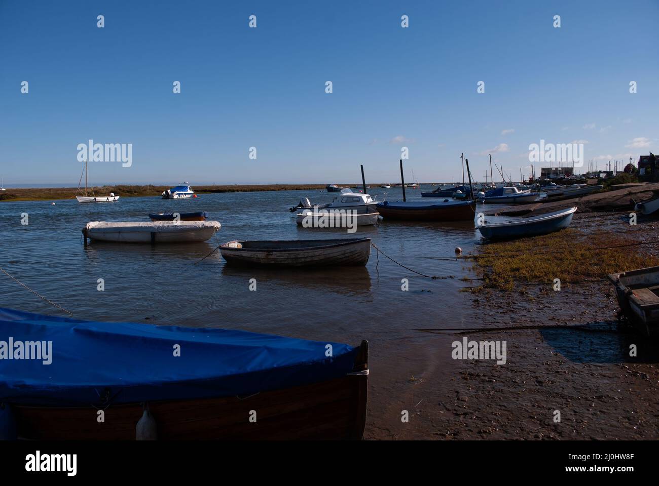 Boats stranded onshore by the low tide with a salt marsh in Wells ...