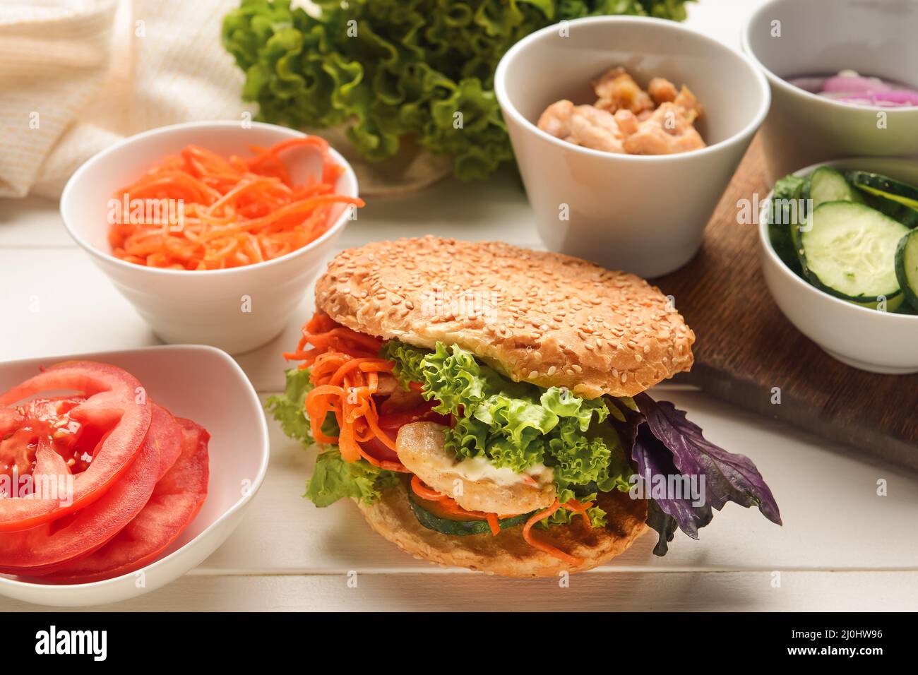 Fresh doner kebab in bun and ingredients on white wooden background ...