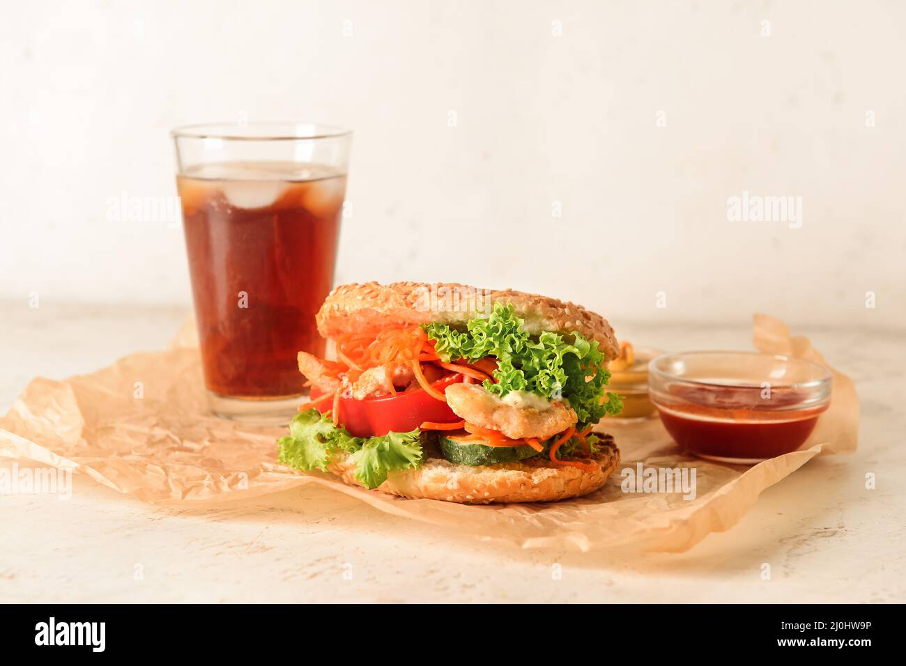 Fresh doner kebab in bun with sauce and glass of cola drink on light ...