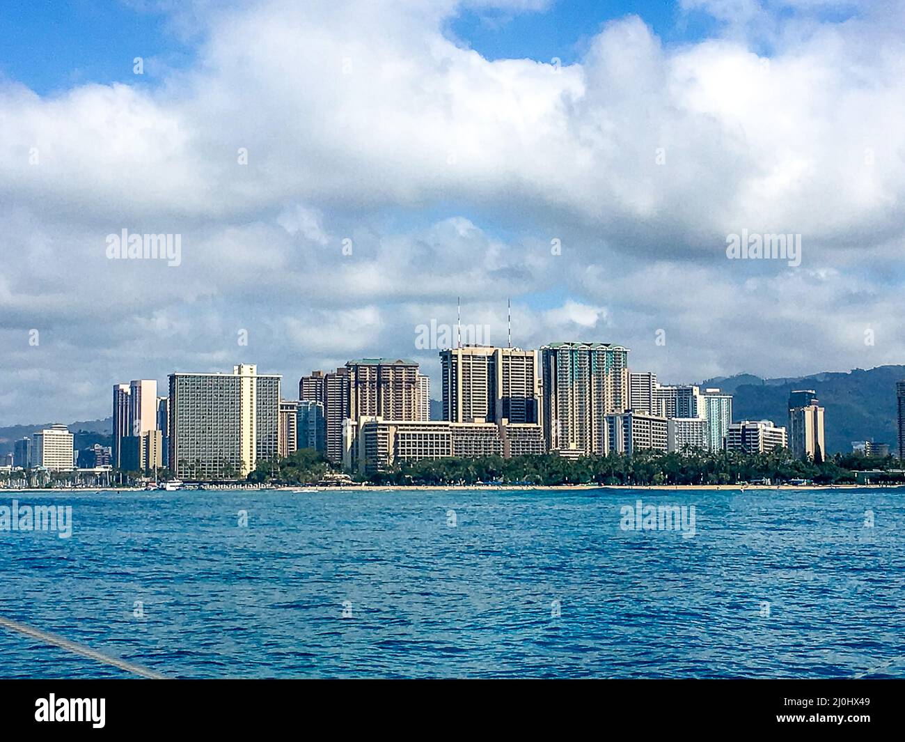 Beautiful view of a city with tall buildings from a sea under the blue ...