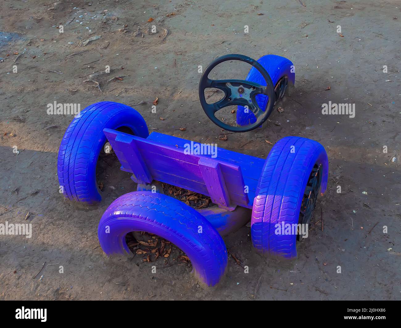 Blue decorative bench made of wood and car wheels with a steering wheel ...