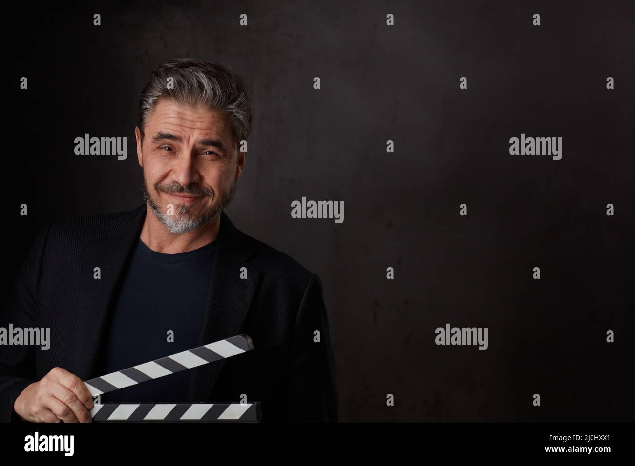 Happy man holding black clapper board. Movie director starting film ...