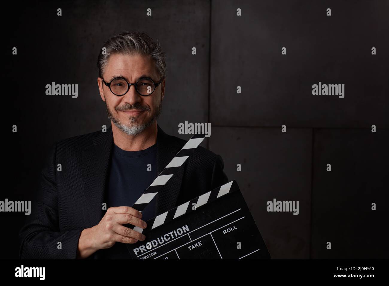 Happy man holding black clapper board. Movie director starting film ...